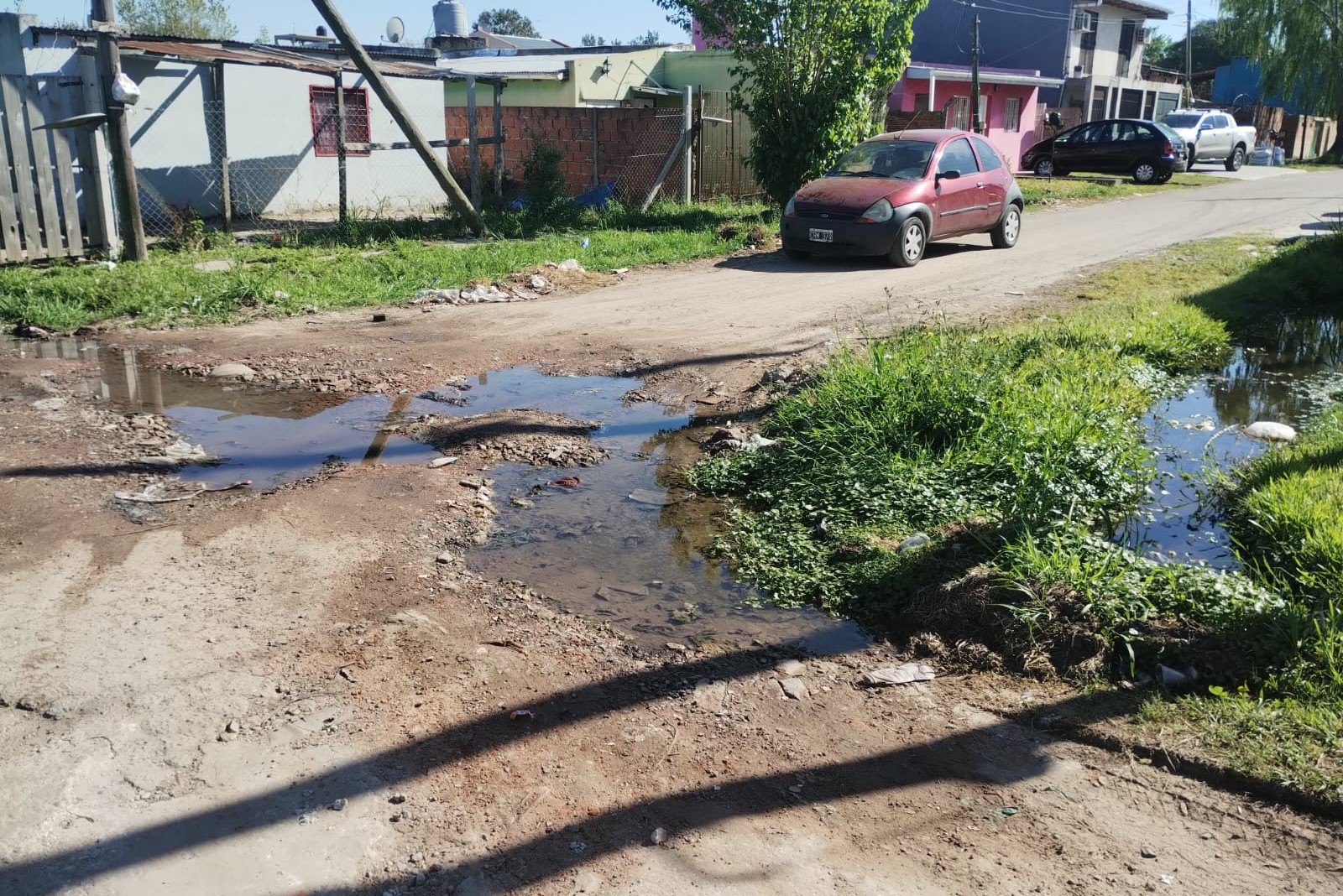 Cruce de calles tapados con agua servida y enfrente un basural